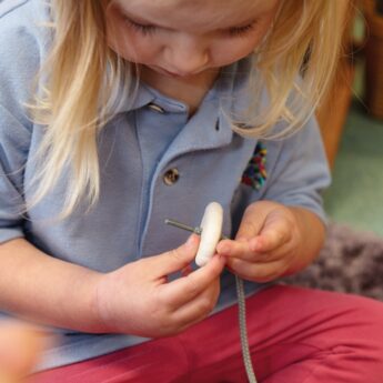 Threading Pebbles - four shapes, textures and shades for sorting
